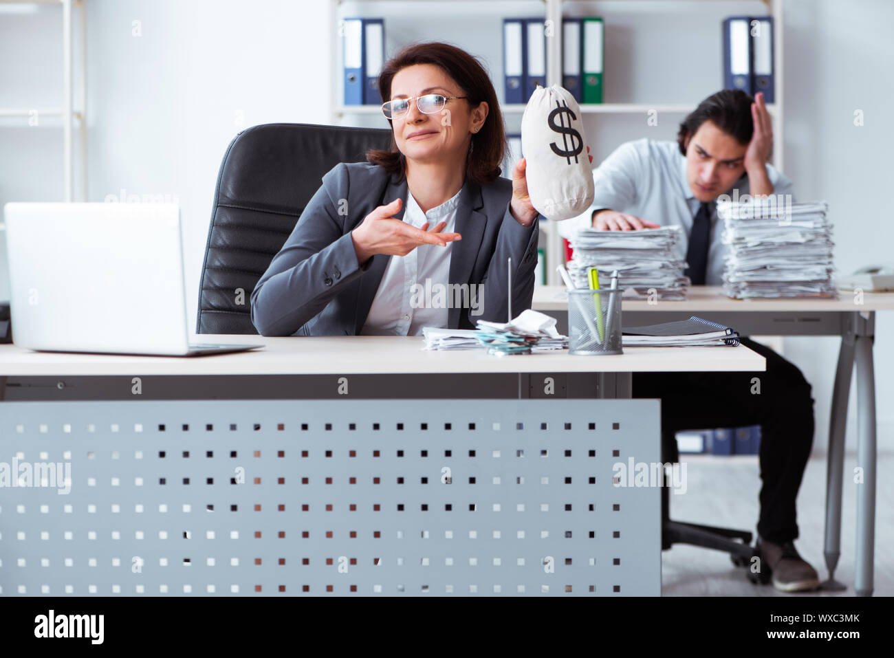 Old female boss and young male employee in the office Stock Photo - Alamy