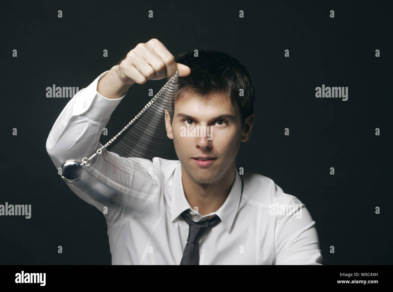 Businessman holding a pocket watch and swinging it in the fashion of a ...