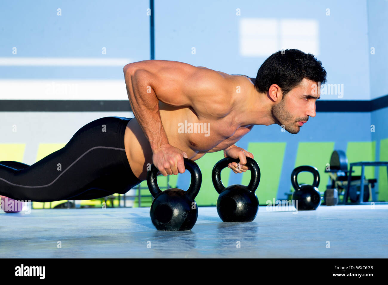 Gym man push-up strength pushup exercise with Kettlebell in a crossfit ...