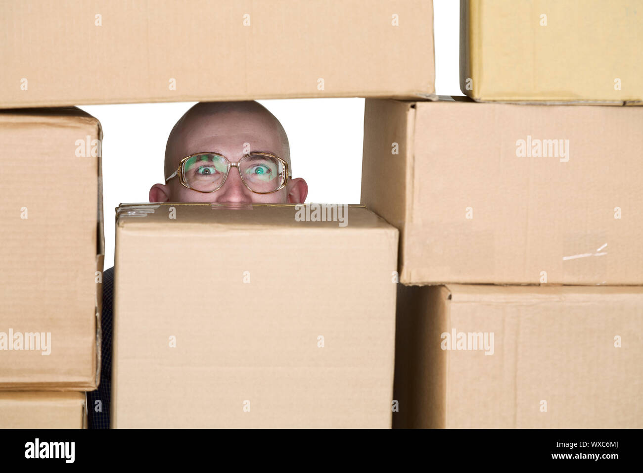 Man looking through window in pile of cardboard boxes Stock Photo - Alamy