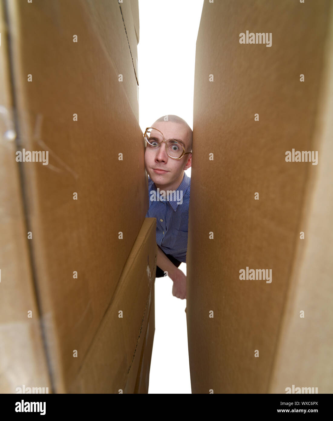 Male face clamping between walls from cardboard boxes Stock Photo - Alamy