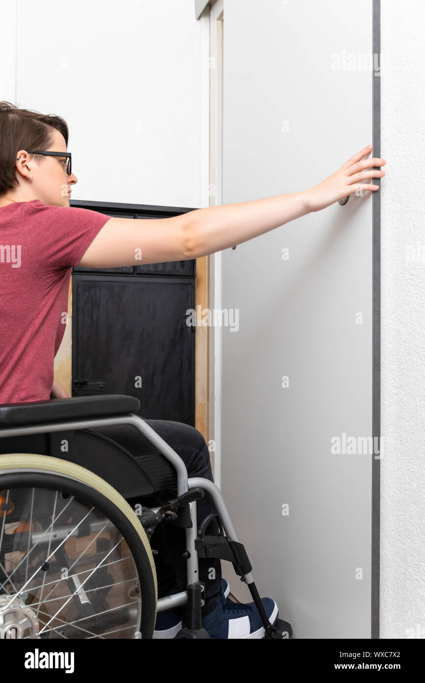 disabled woman opens a door in her flat Stock Photo - Alamy
