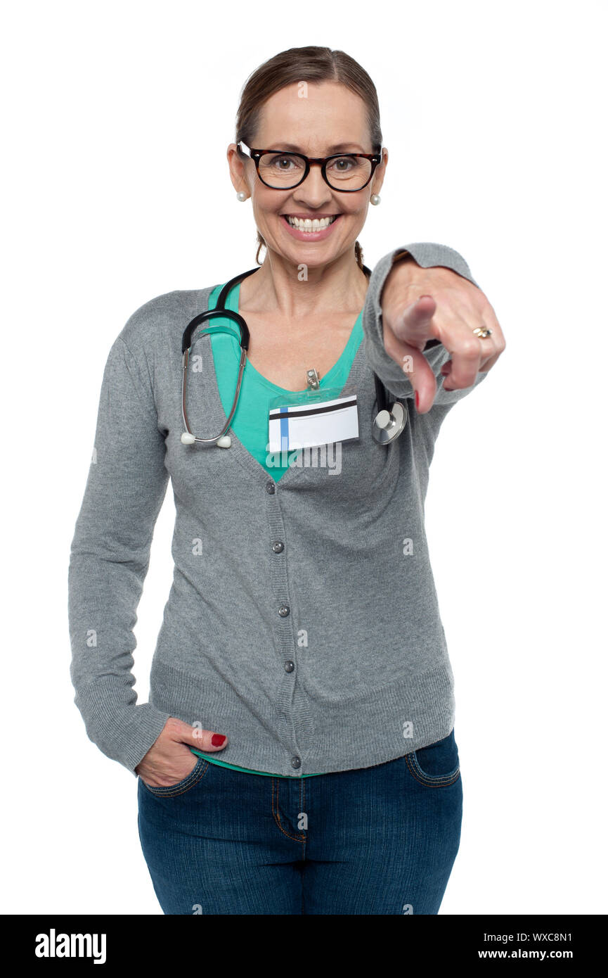 Cheerful medical practitioner pointing at the camera. All on white ...