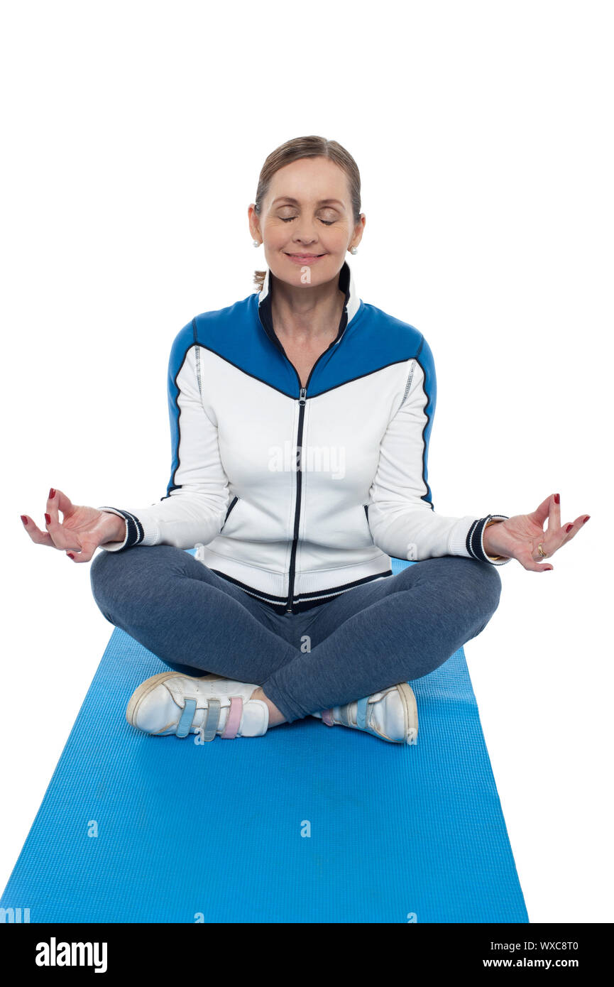 Portrait of a woman sitting in a lotus position. Isolated over white ...