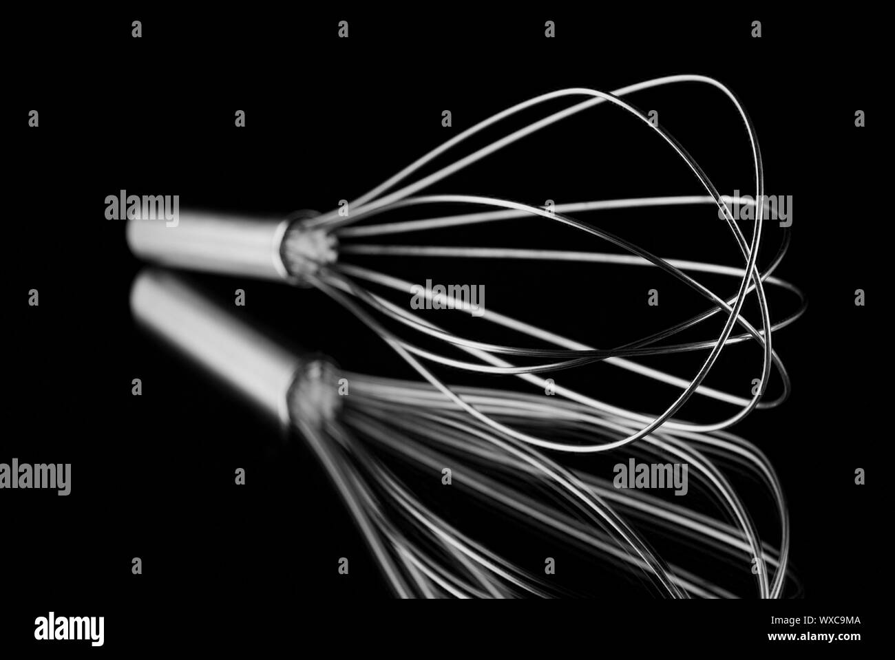 Single whisk reflection with black background Stock Photo - Alamy