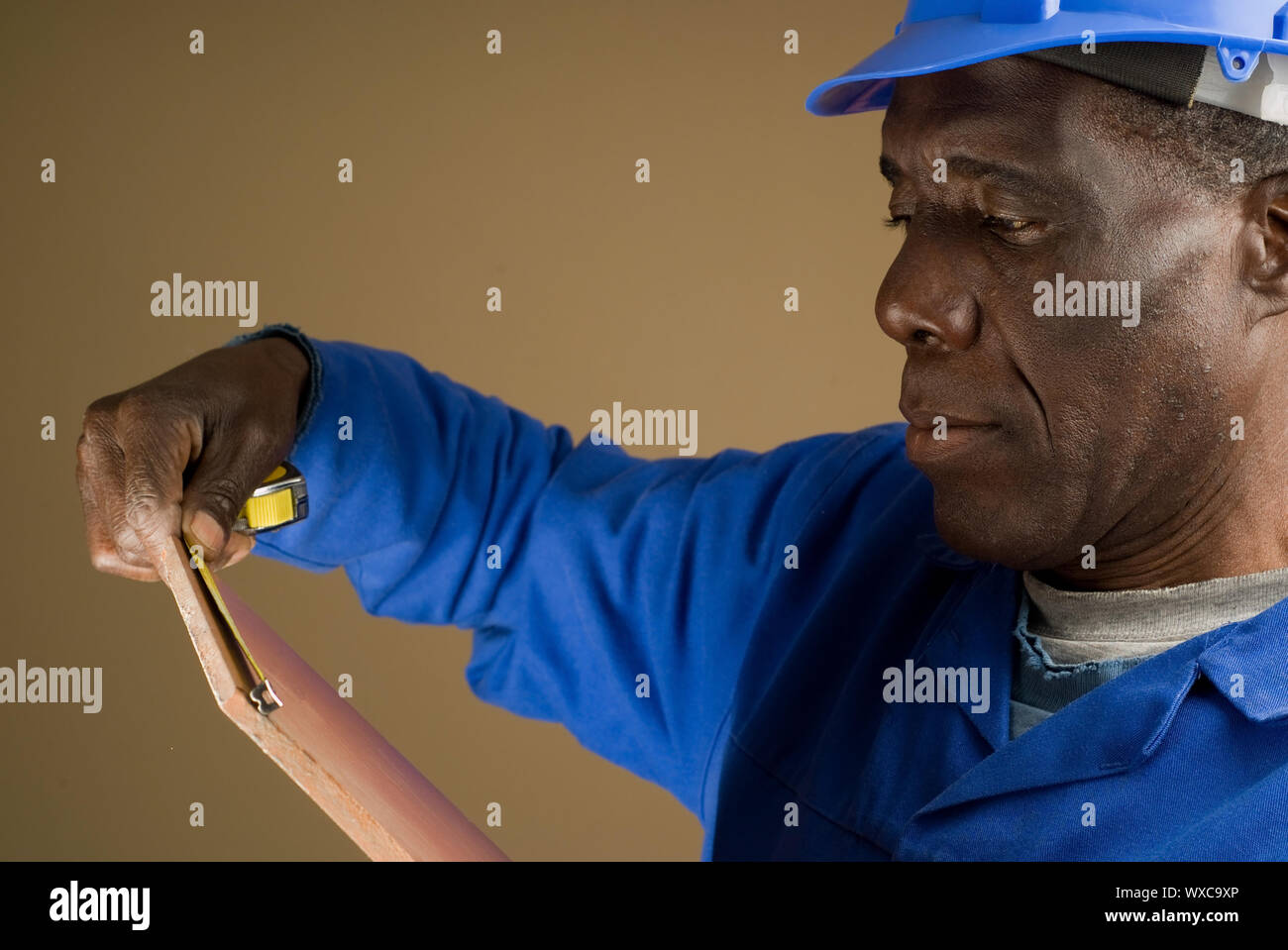African American Construction Worker Measuring Tile with Measuring Tool ...