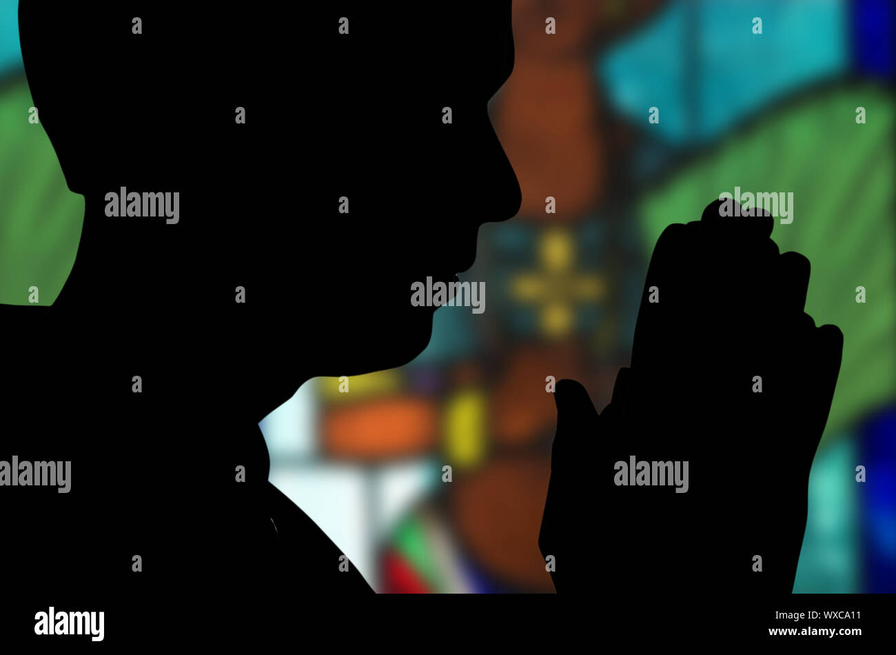 Man praying in front of stained glass window Stock Photo - Alamy