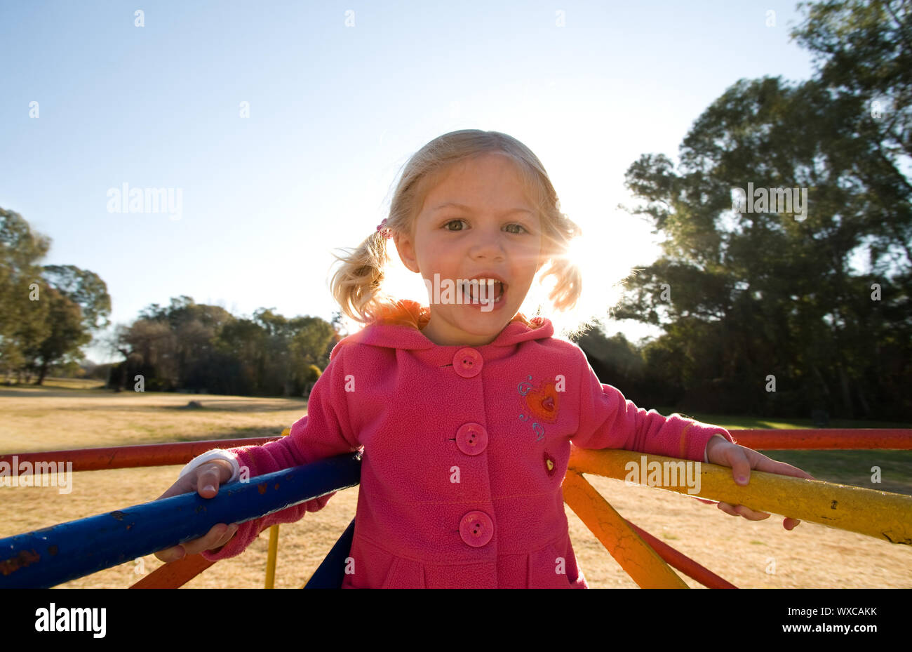 Happy young girl child play on roundabout in park Stock Photo - Alamy