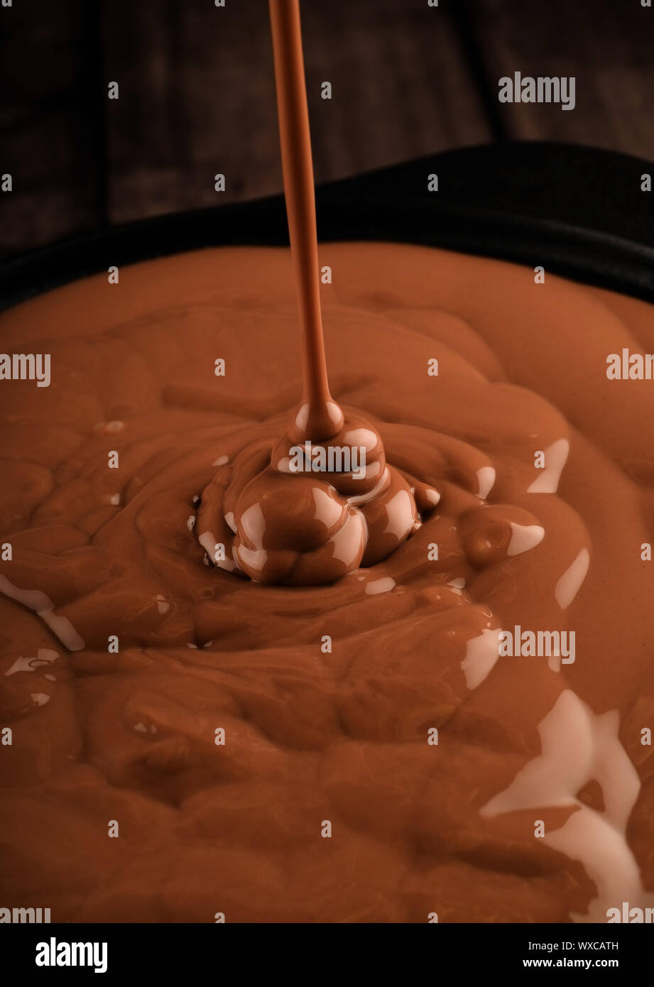 Melted or moulten chocolate poured into cooking pot Stock Photo - Alamy