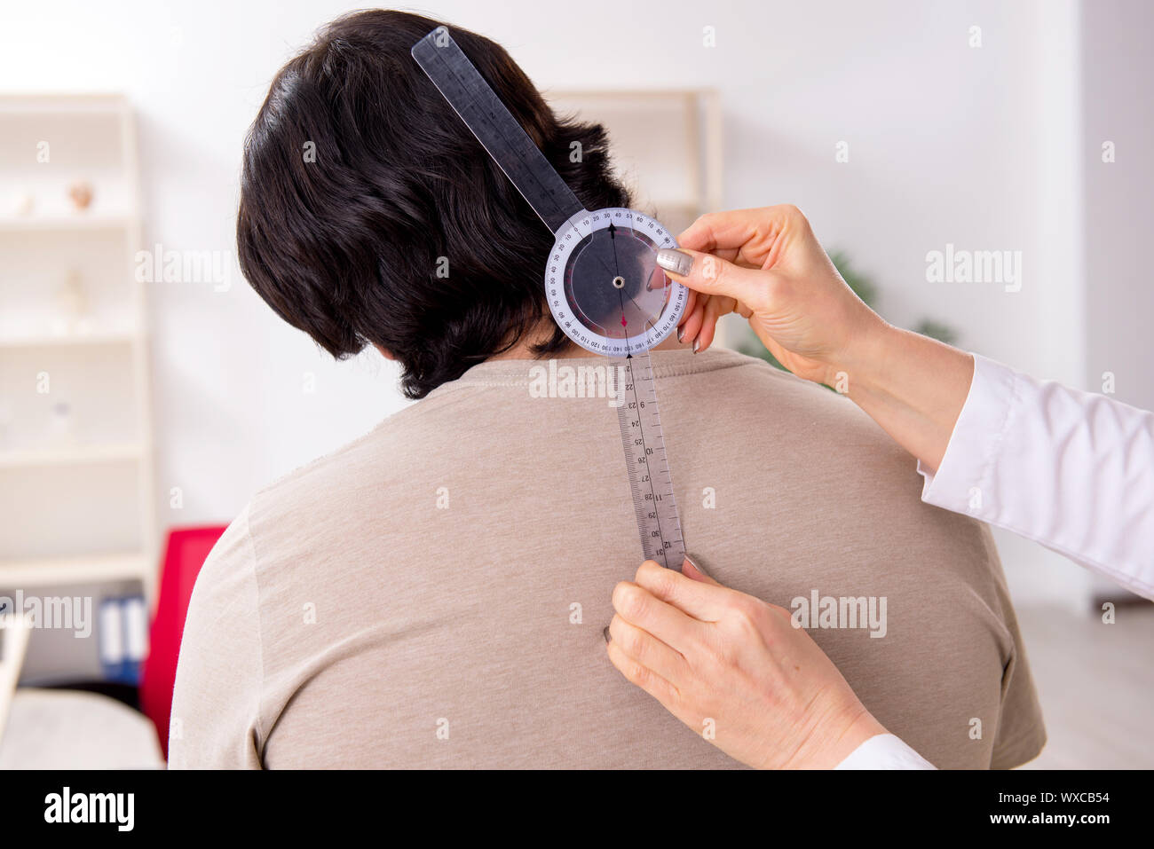 Female doctor checking patient's joint flexibility with goniometer ...