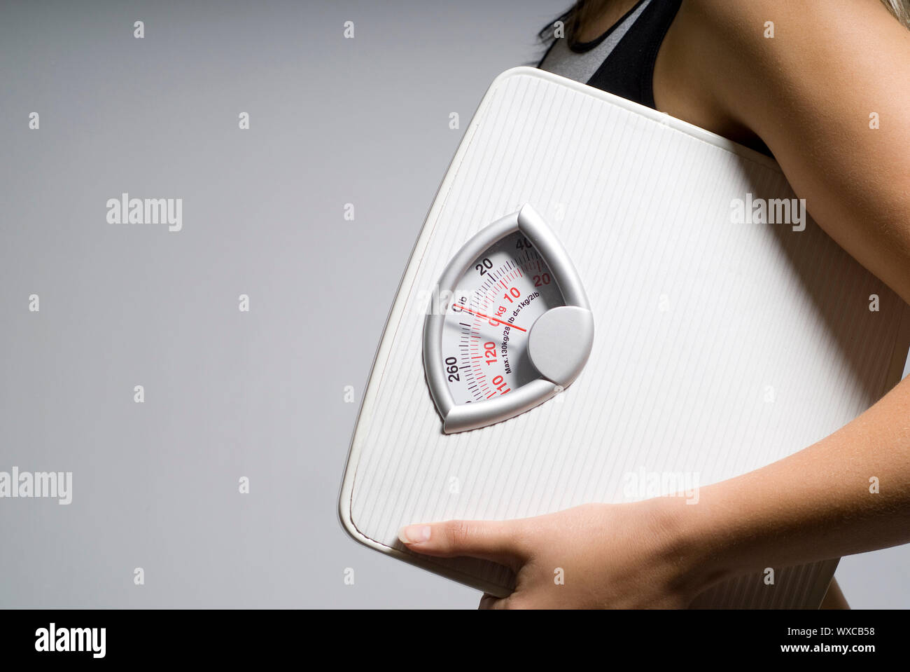 Diet or dieting scale concept held by slim, healthy or trim woman close ...