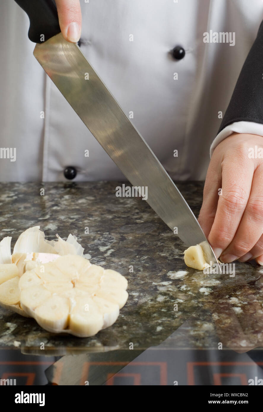 Chef Wearing Black and White Uniform Slicing Clove of Garlic Stock ...