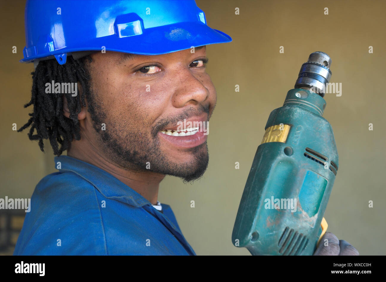 Smiling construction worker with power tool drill Stock Photo - Alamy
