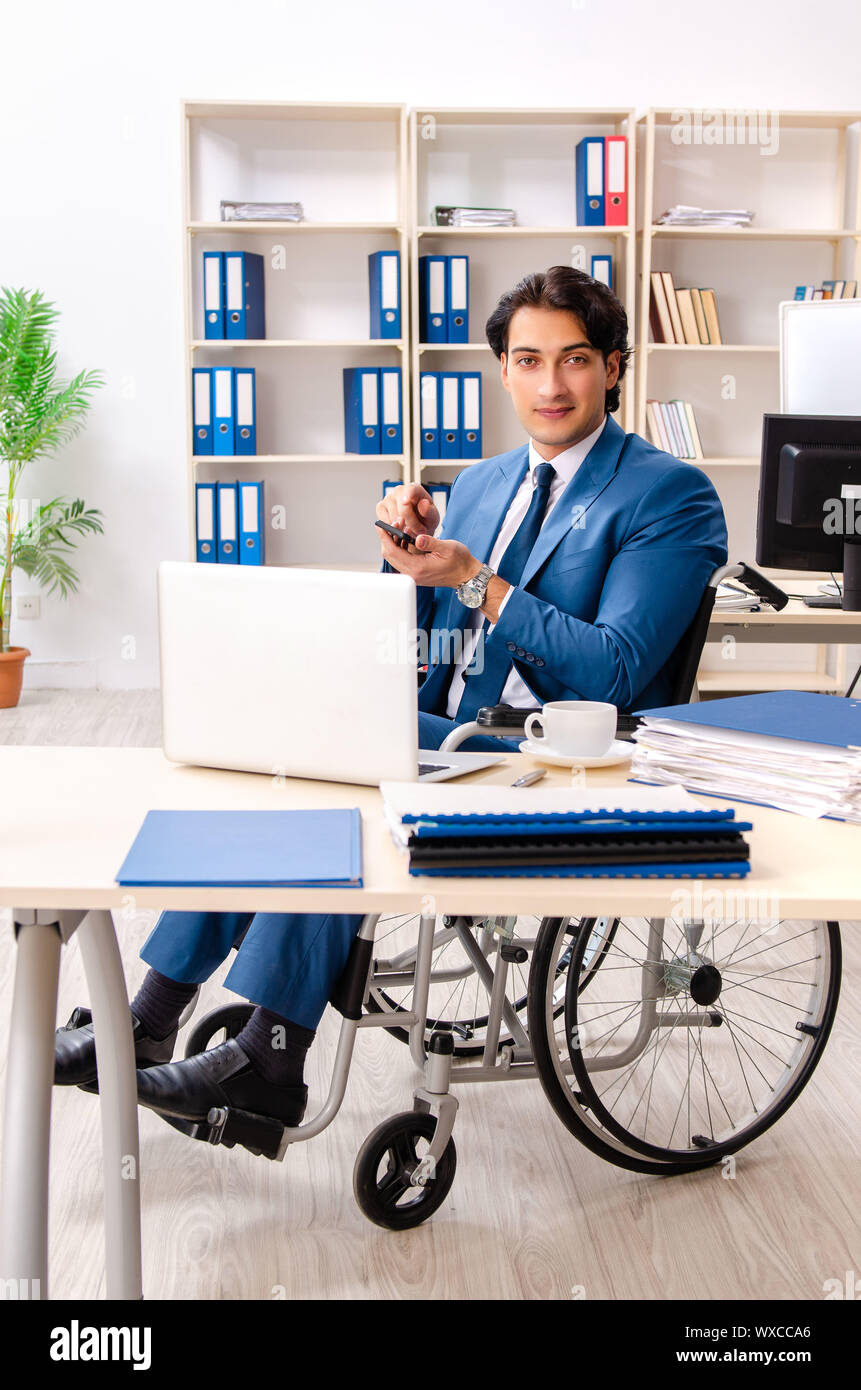 Male employee in wheelchair working at the office Stock Photo - Alamy
