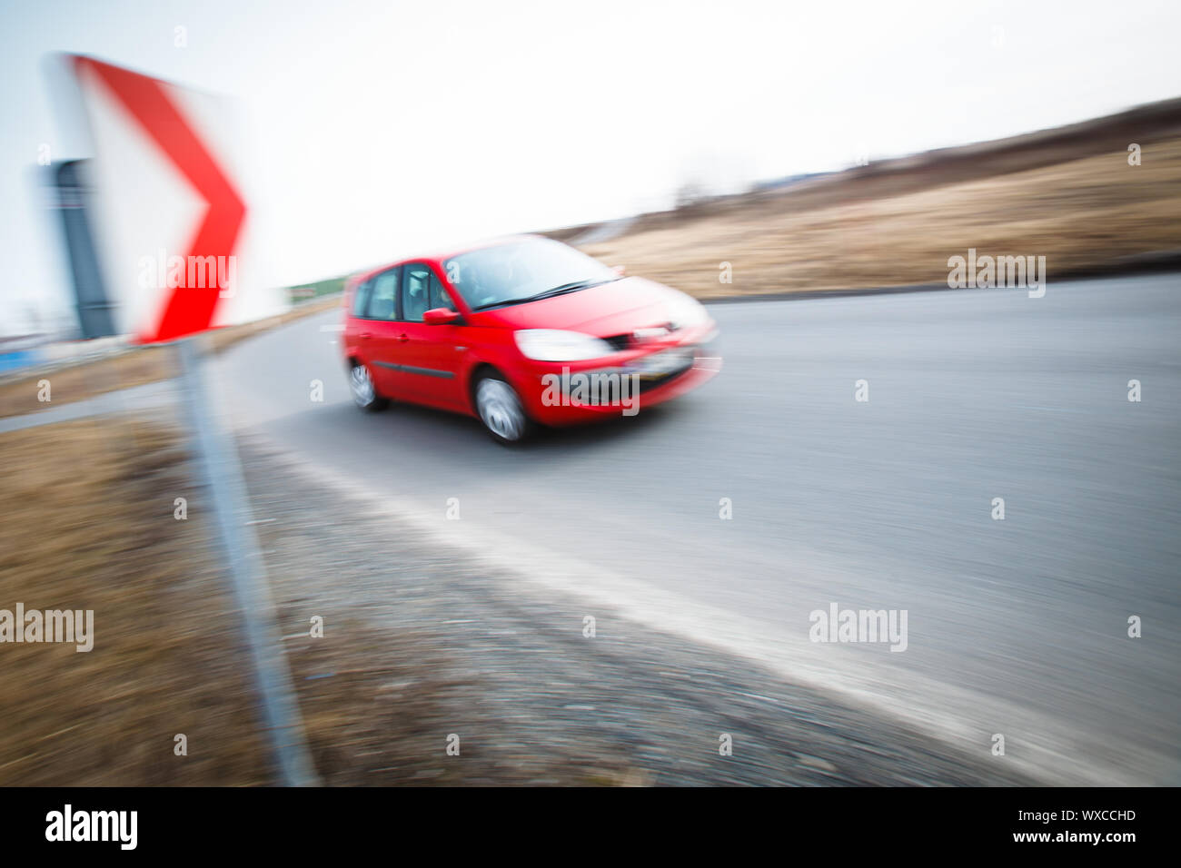 Traffic concept: car driving fast through a sharp turn (motion blur is ...