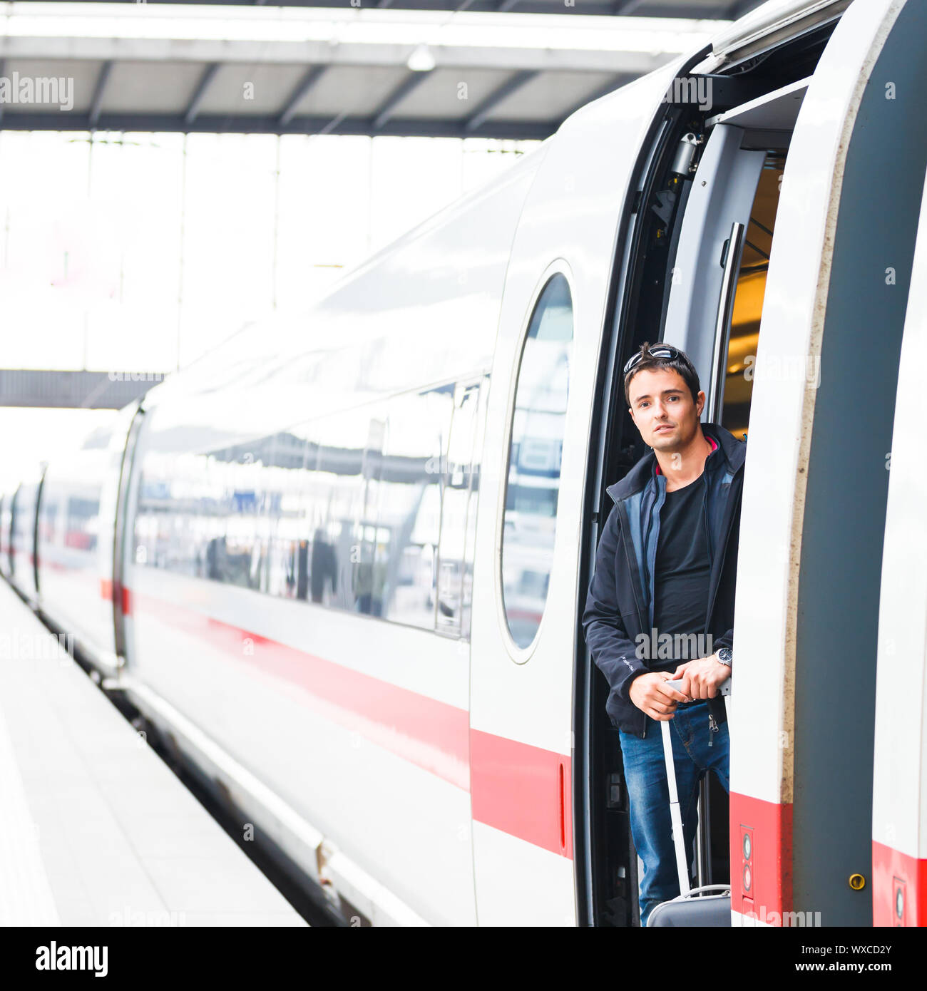 Train travel - Handsome young man taking a train Stock Photo - Alamy