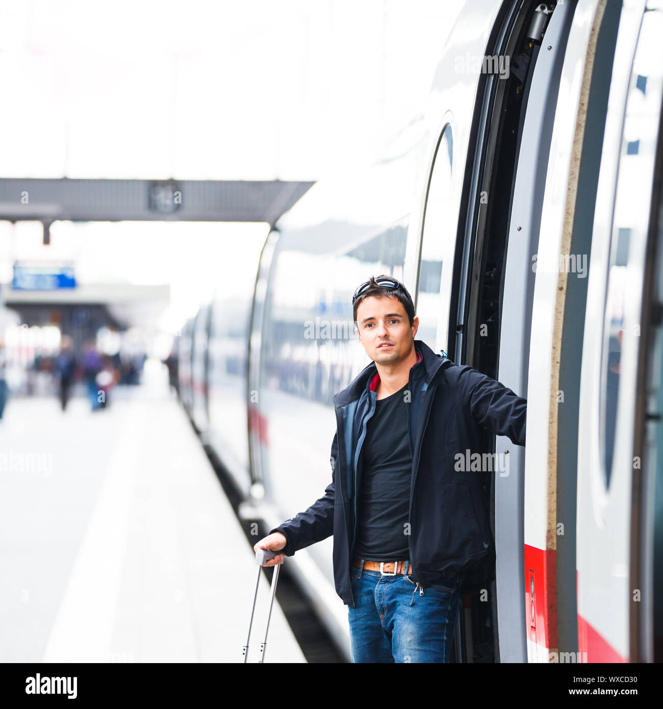 Train travel - Handsome young man taking a train Stock Photo - Alamy