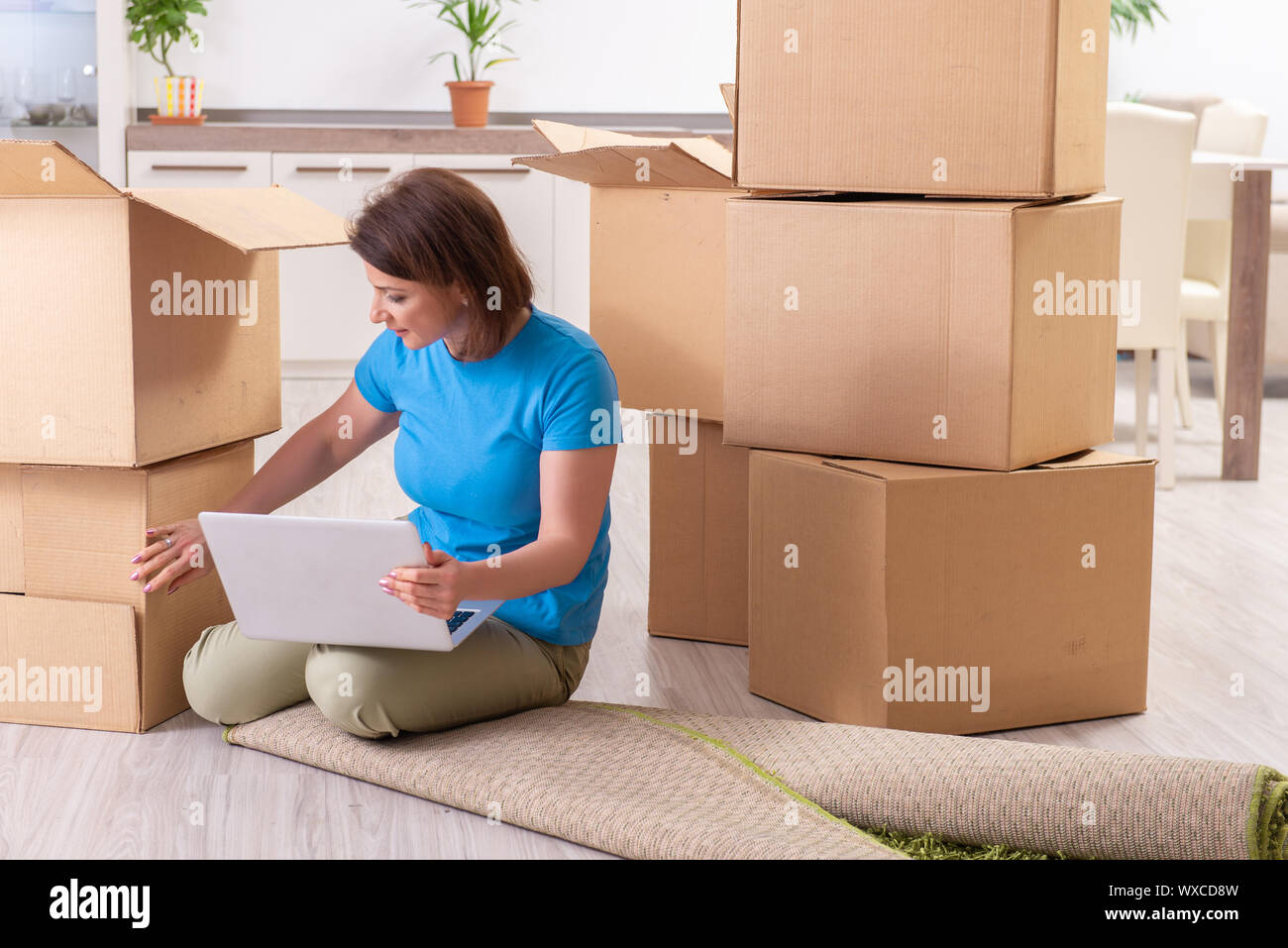 Middle-aged woman moving to new flat Stock Photo - Alamy