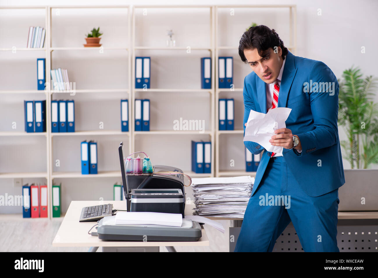 Young employee making copies at copying machine Stock Photo - Alamy