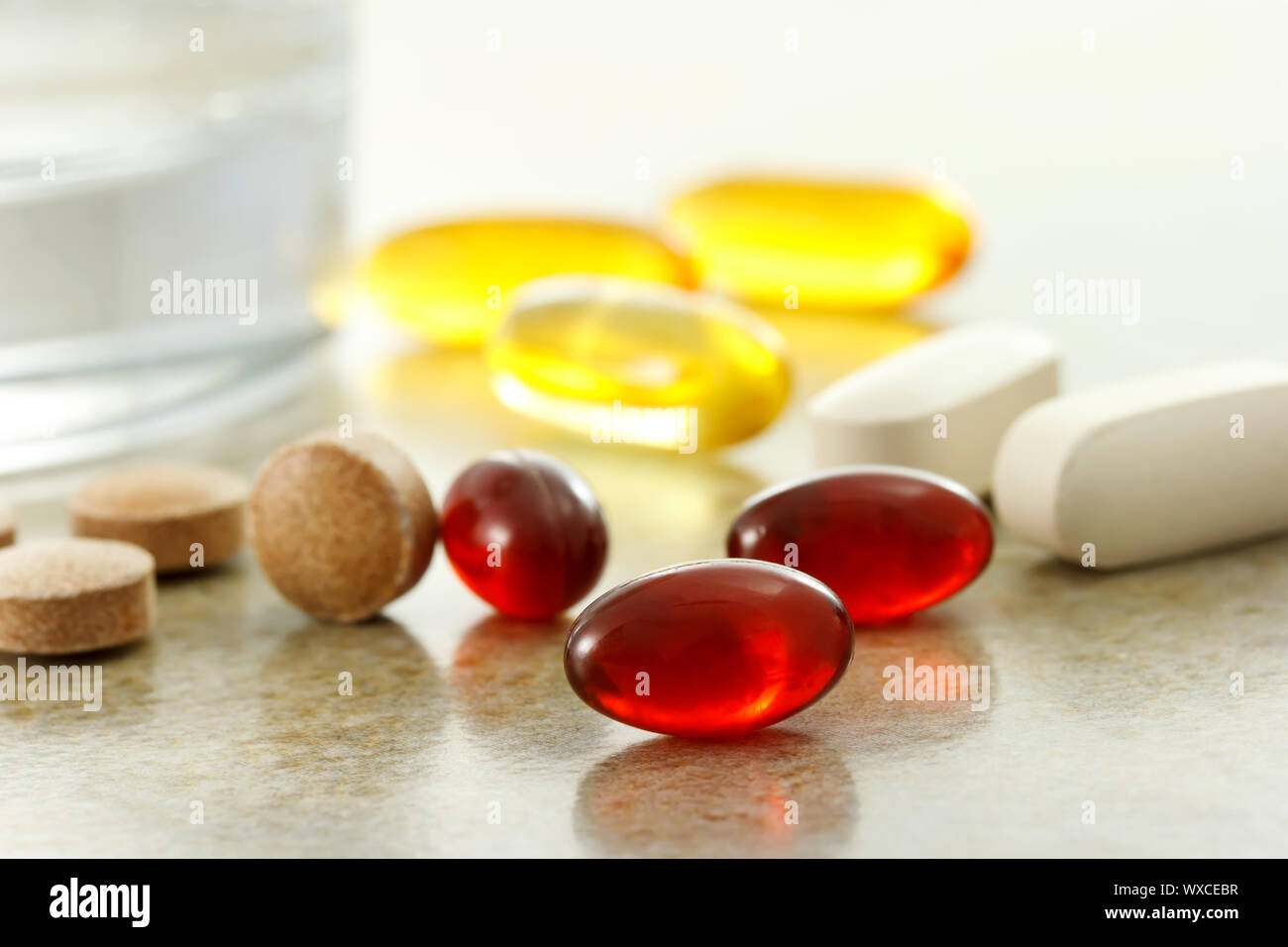 Supplement capsules and glass of water Stock Photo - Alamy