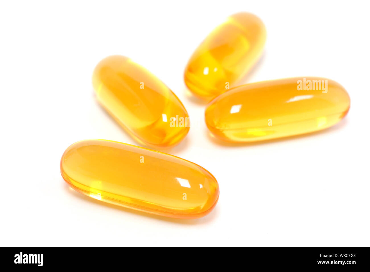 Yellow gel capsules isolated on white background Stock Photo - Alamy