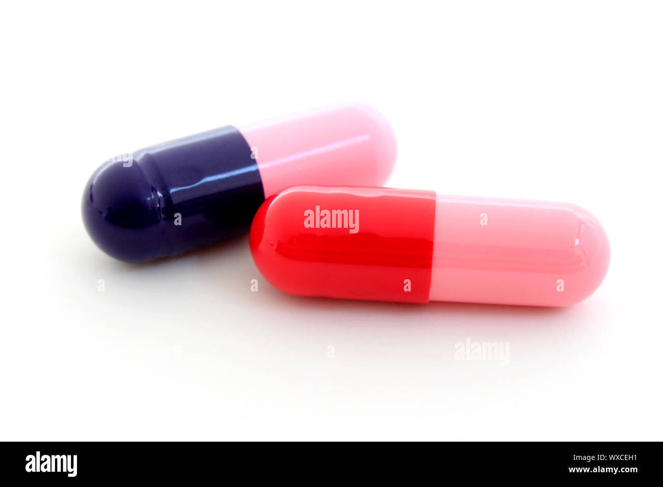 Blue and red capsules isolated on white background Stock Photo - Alamy