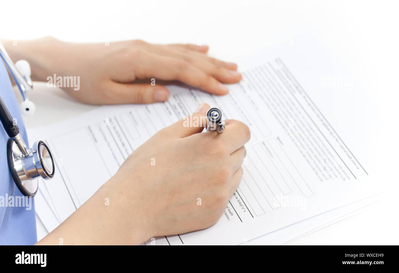 Female doctor doing paper work over white background Stock Photo - Alamy