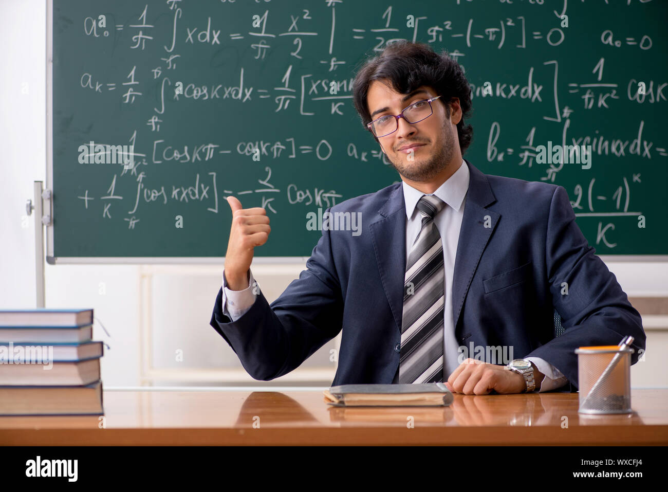 Young male math teacher in classroom Stock Photo - Alamy