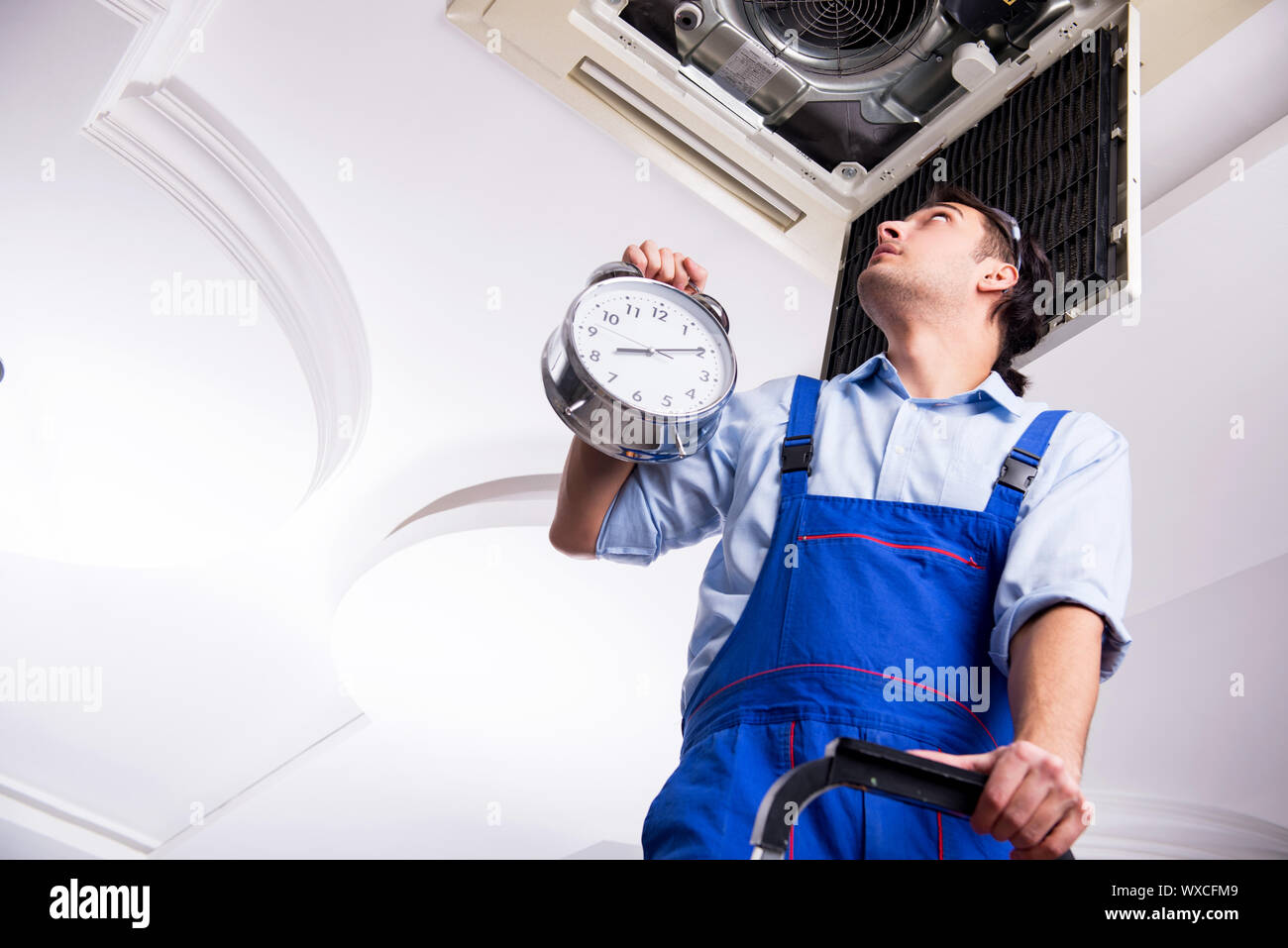 Young repairman repairing ceiling air conditioning unit Stock Photo - Alamy
