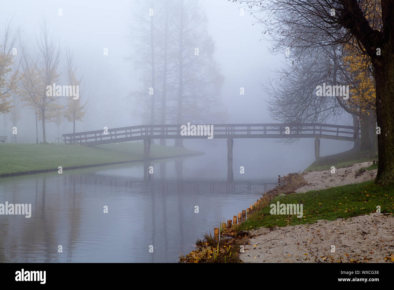 wooden bridge over canal in dense fog Stock Photo - Alamy