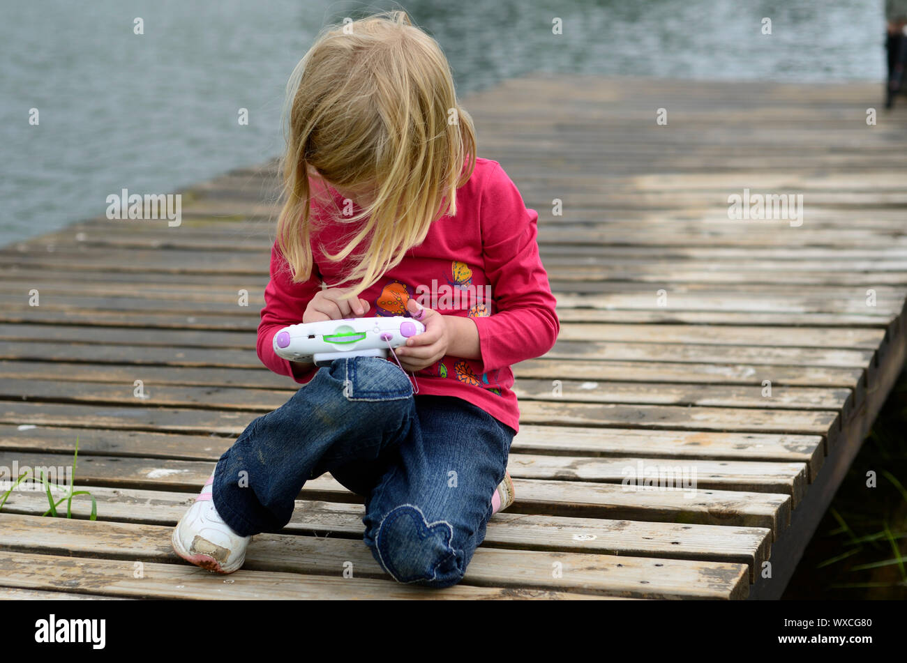 Modern young girl playing computer game in nature Stock Photo - Alamy