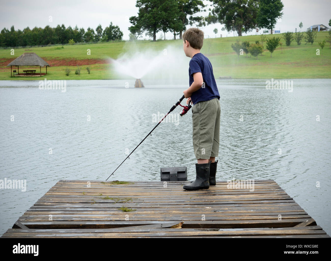 Boy bass fishing on dam or lake pier Stock Photo - Alamy