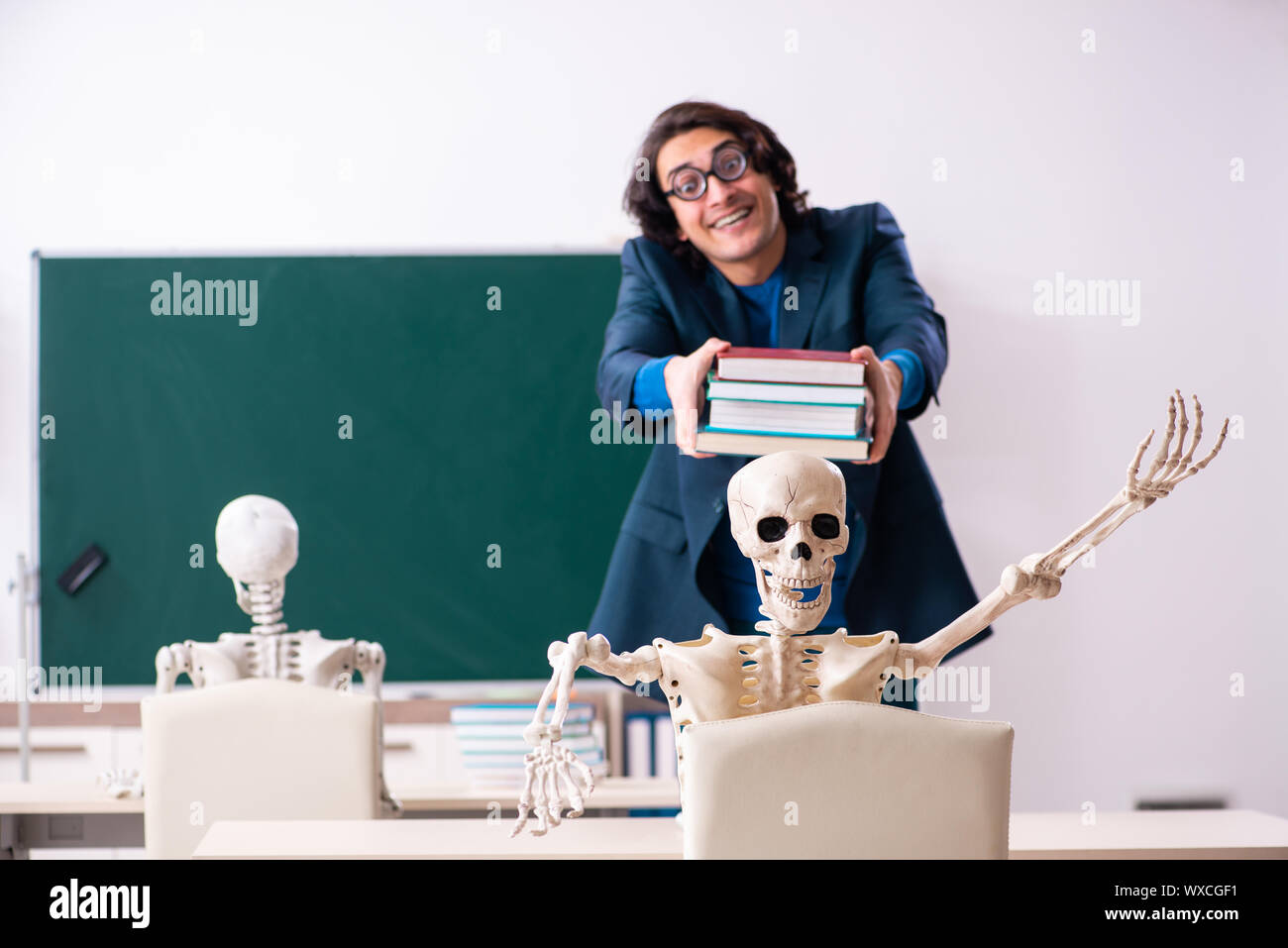 Male teacher and skeleton student in the classroom Stock Photo - Alamy