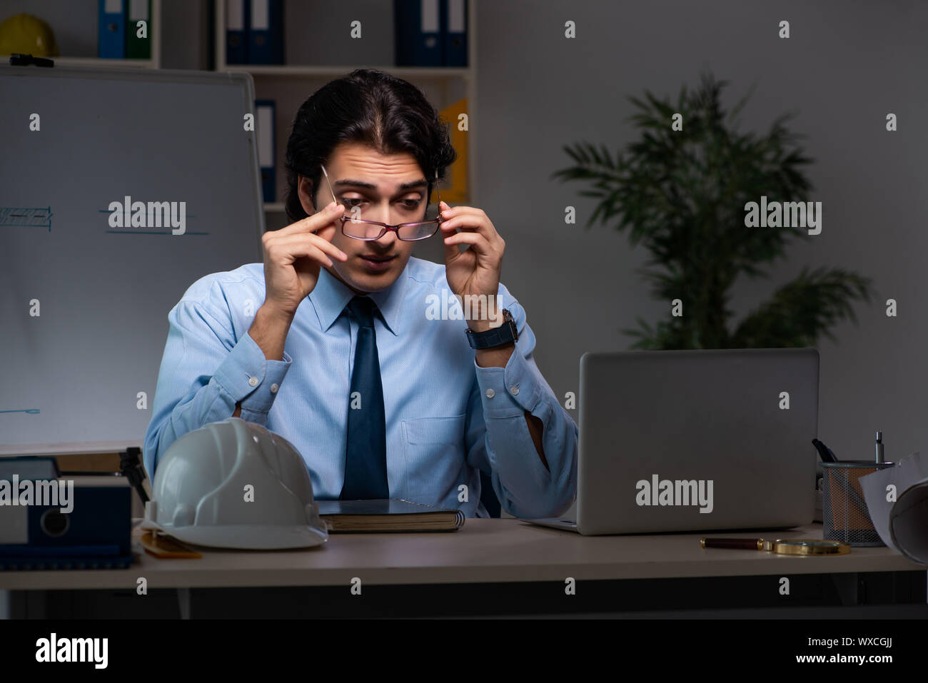 Young male architect working night at office Stock Photo - Alamy