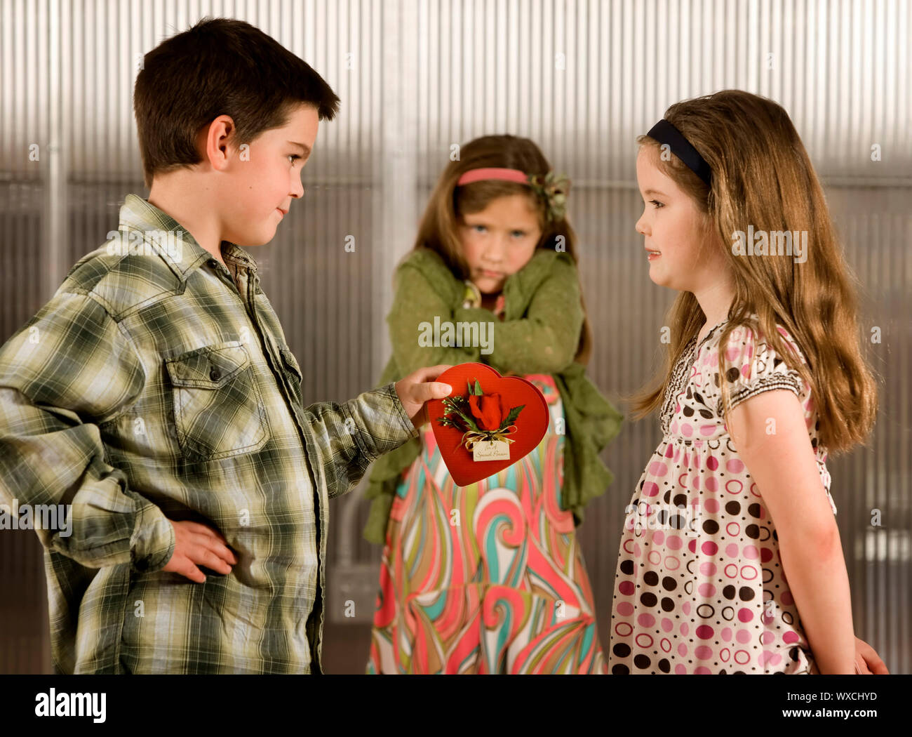 Little boy giving a candy heart to girl causes anger Stock Photo - Alamy