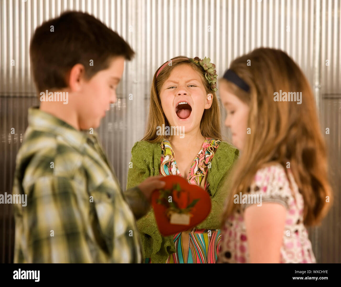 Little boy giving a candy heart to girl causes anger Stock Photo - Alamy