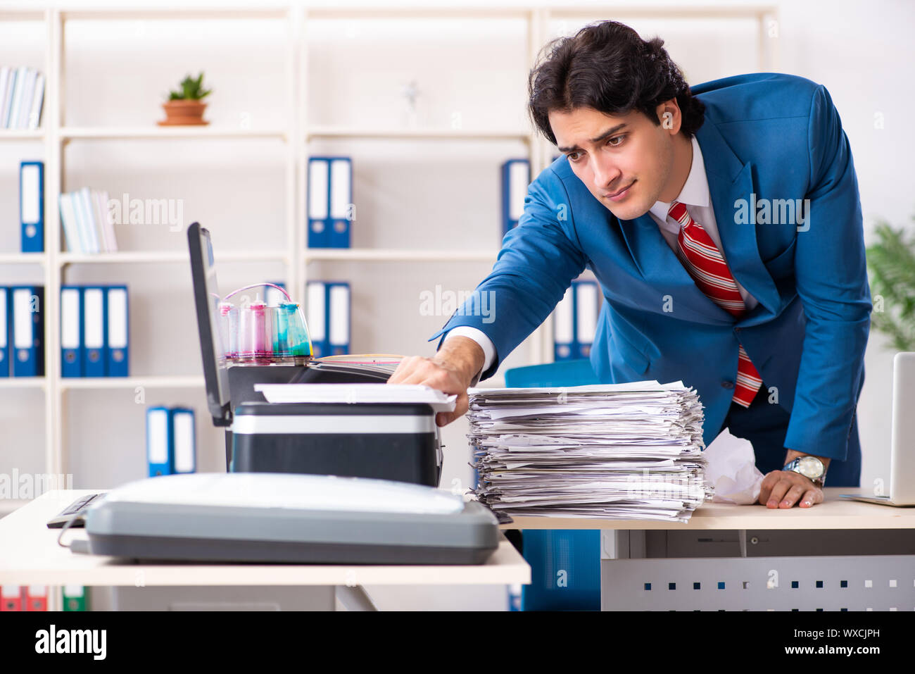 Young employee making copies at copying machine Stock Photo - Alamy