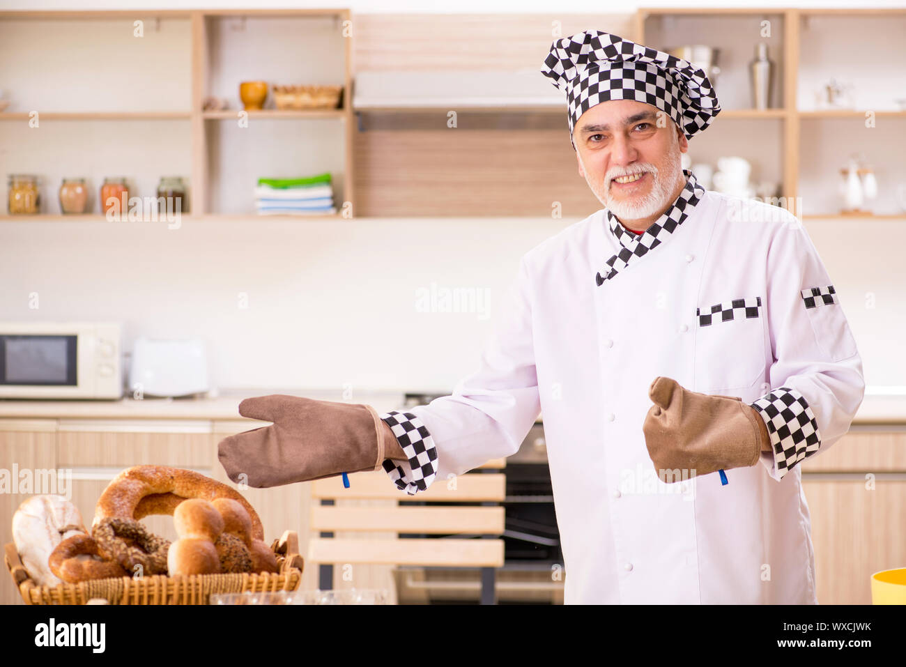Old male baker working in the kitchen Stock Photo - Alamy
