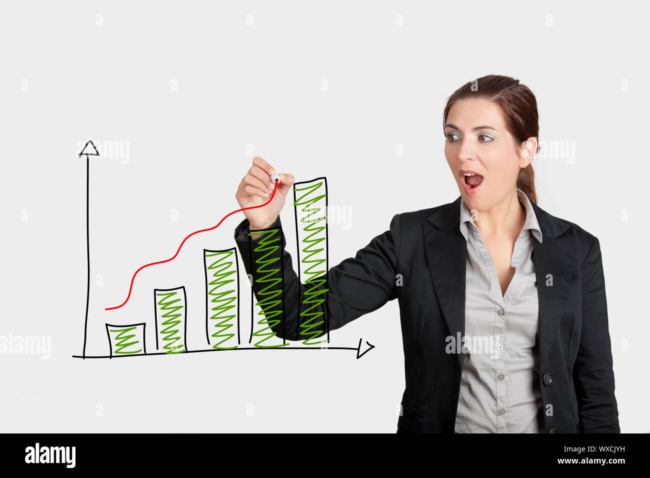 Beautiful woman drawing a business chart on a glass board with a marker ...