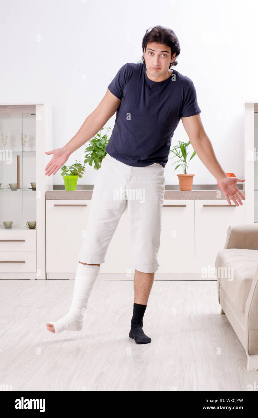 Leg injured young man suffering at home Stock Photo - Alamy