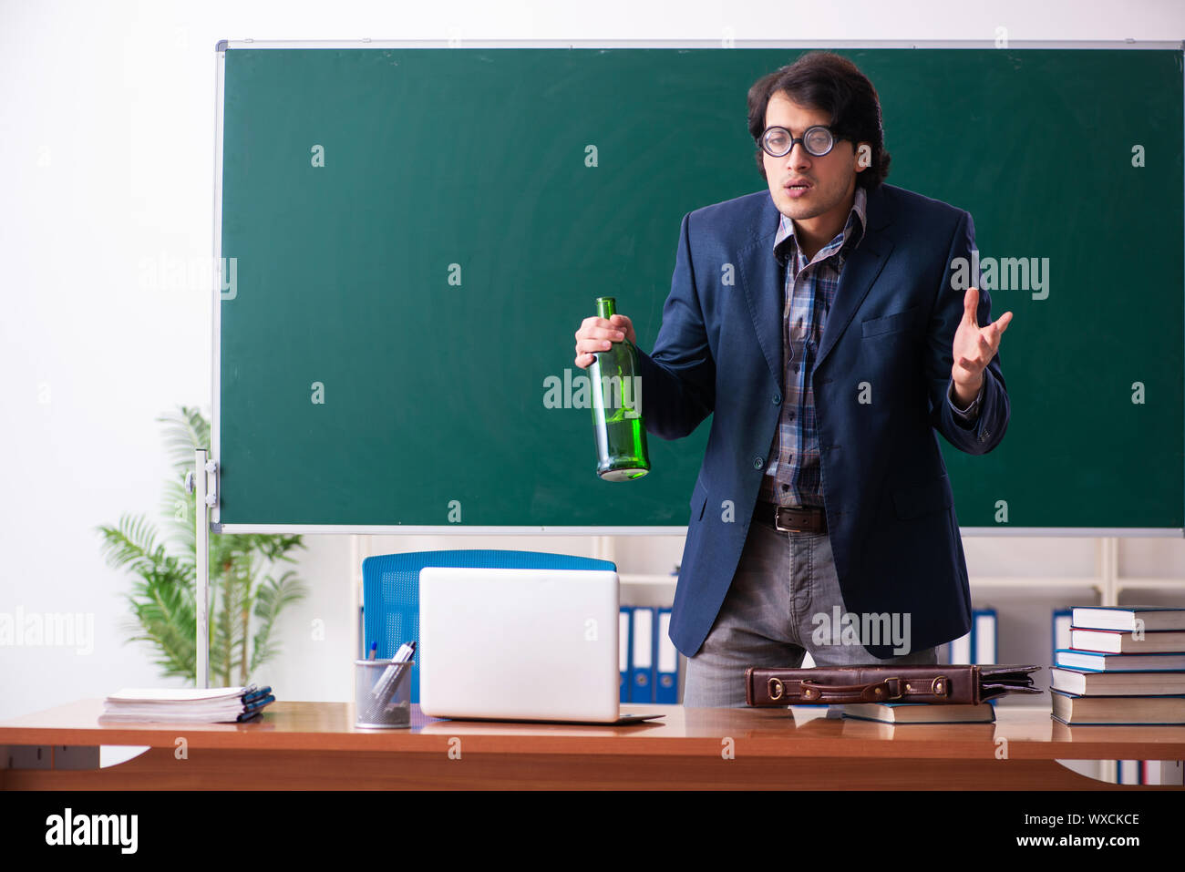 Male teacher drinking in the classroom Stock Photo - Alamy