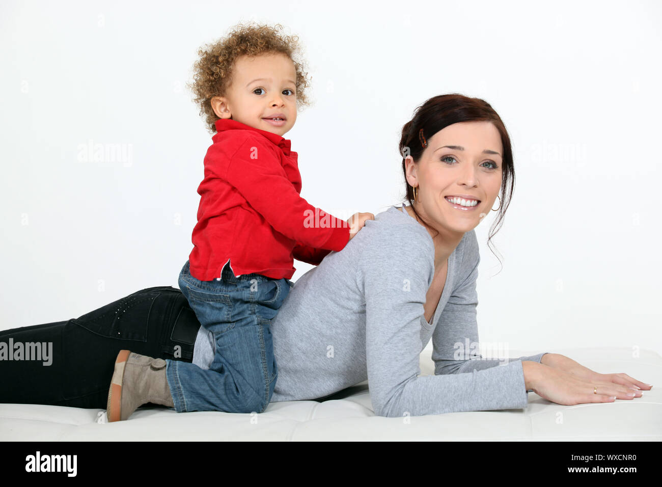 little boy sitting on the back of his mother Stock Photo - Alamy
