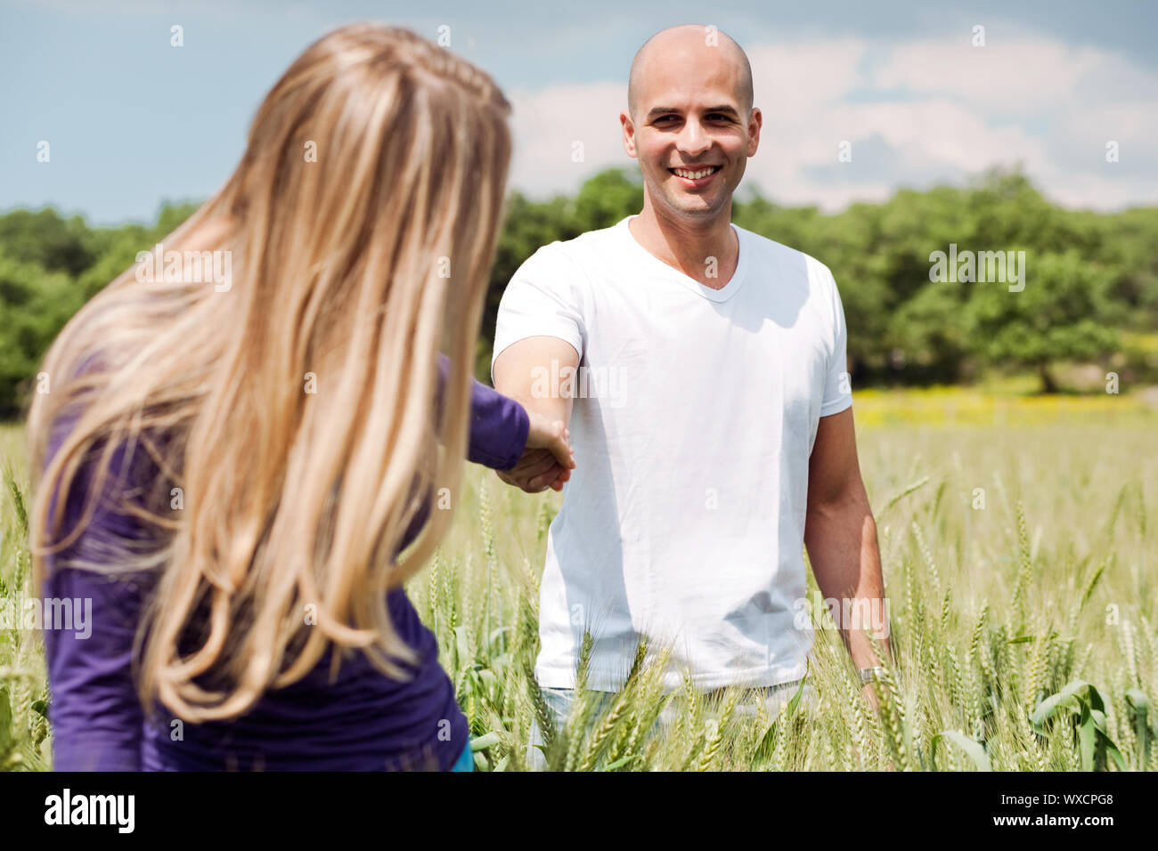Girlfriend pulling her boyfriend in love in the farm Stock Photo - Alamy
