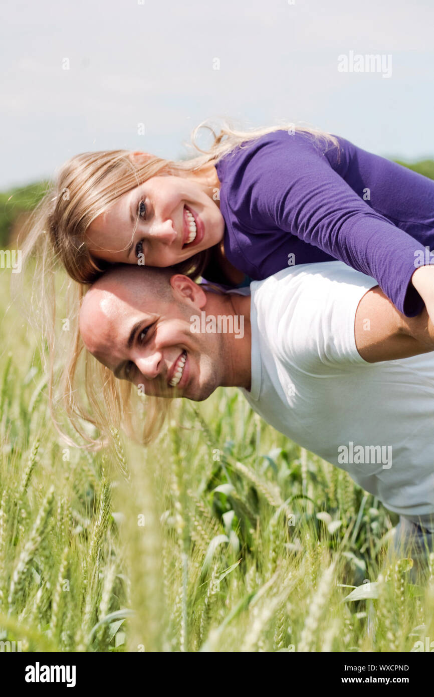 Man giving his wife a piggyback ride in the park Stock Photo - Alamy