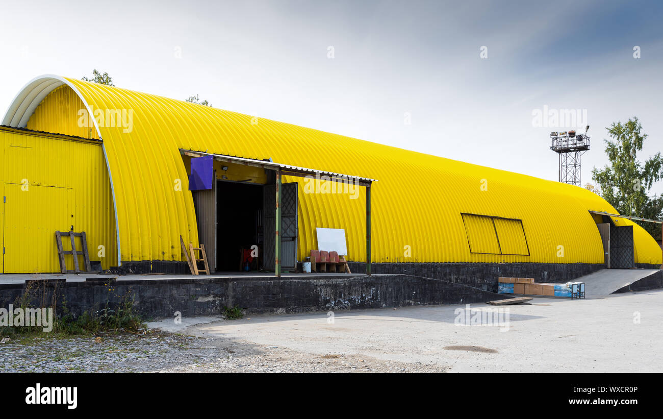 Facade of a yellow metal warehouse, commercial building for storage of ...