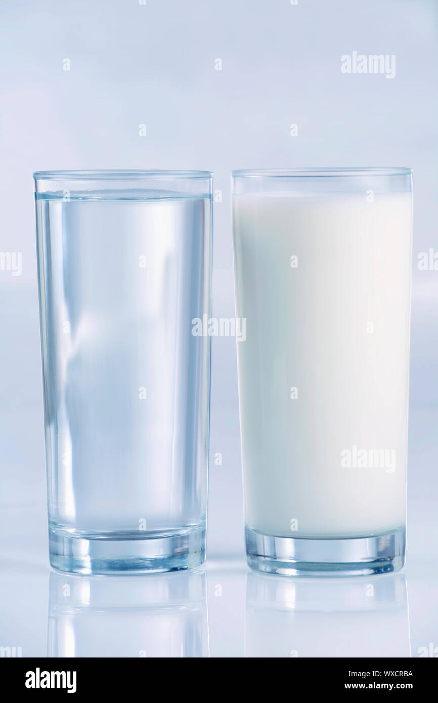 Glass of water and milk, side by side, with blue tones,. Shallow DOF ...