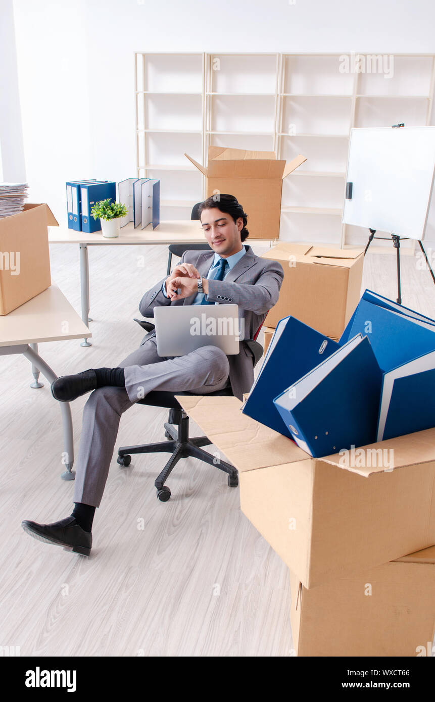 Young man employee with boxes in the office Stock Photo - Alamy