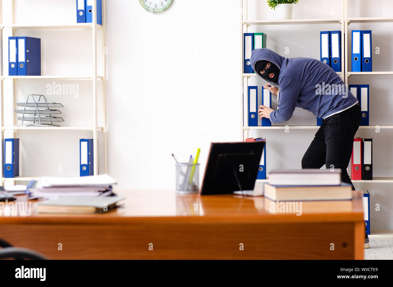 Male thief in balaclava in the office Stock Photo - Alamy