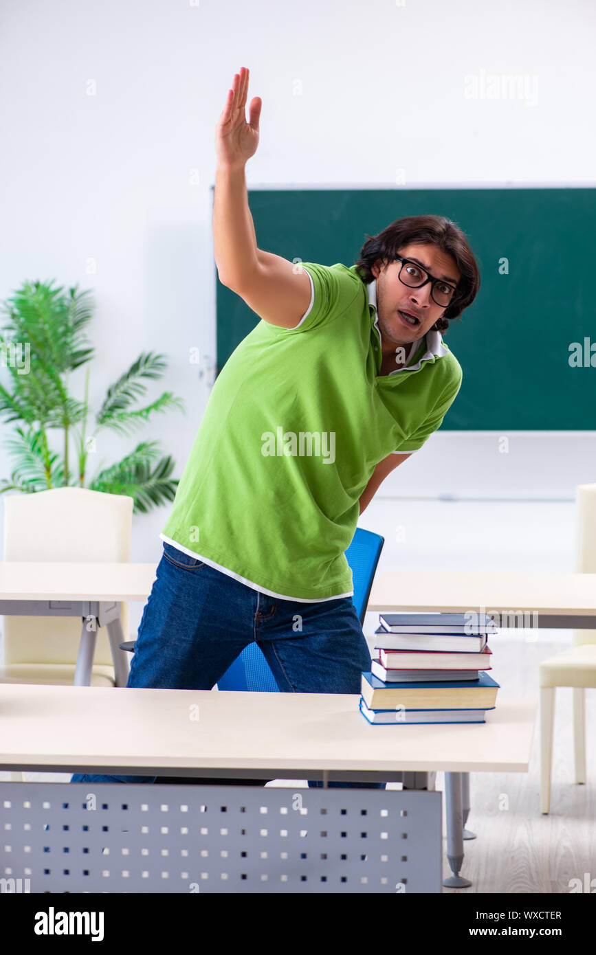 Male student suffering from urge in the classroom Stock Photo - Alamy