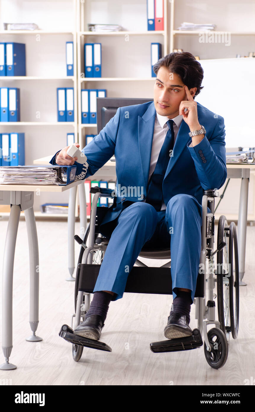 Male employee in wheelchair working at the office Stock Photo - Alamy